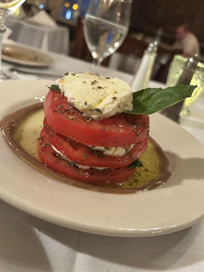Layers of fresh tomato and creamy mozzarella create a caprese tower that's both architectural marvel and flavor explosion. Basil never had better company.