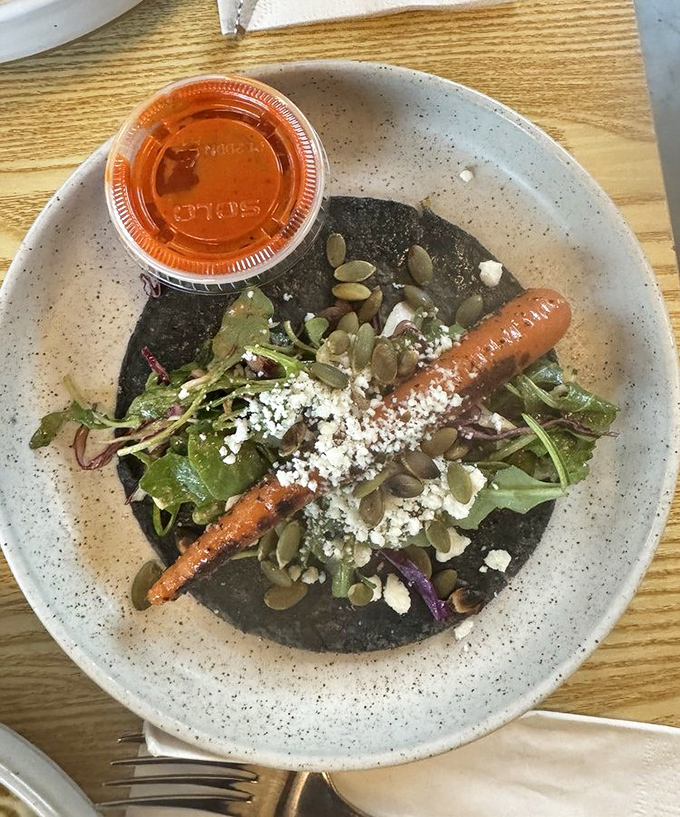 A blue corn tortilla cradles a confit carrot like it's the most precious thing in the world. Vegetarian food that makes carnivores question everything.