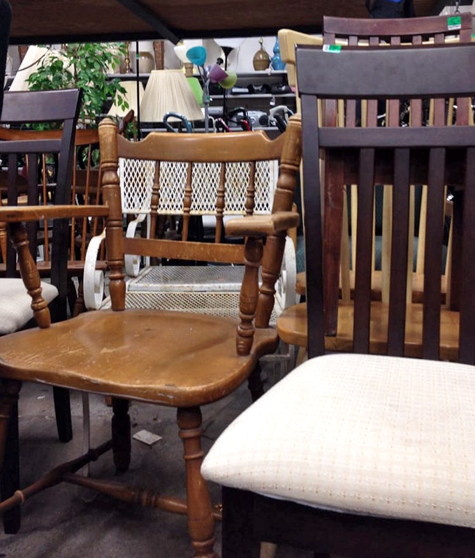 Wooden chairs huddle together like old friends at a reunion, each with stories etched into their worn surfaces, waiting for new homes.