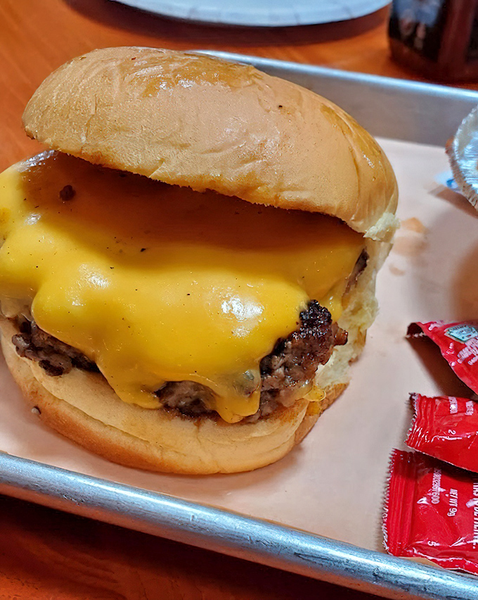 This isn't just a cheeseburger &ndash; it's a commitment to happiness. The melted cheese cascades down the sides like a yellow waterfall of joy.