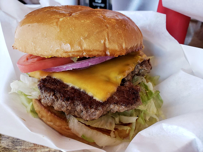 This isn't just a cheeseburger; it's edible architecture—perfectly melted cheese blanketing a crusty patty atop crisp lettuce and a toasted bun.