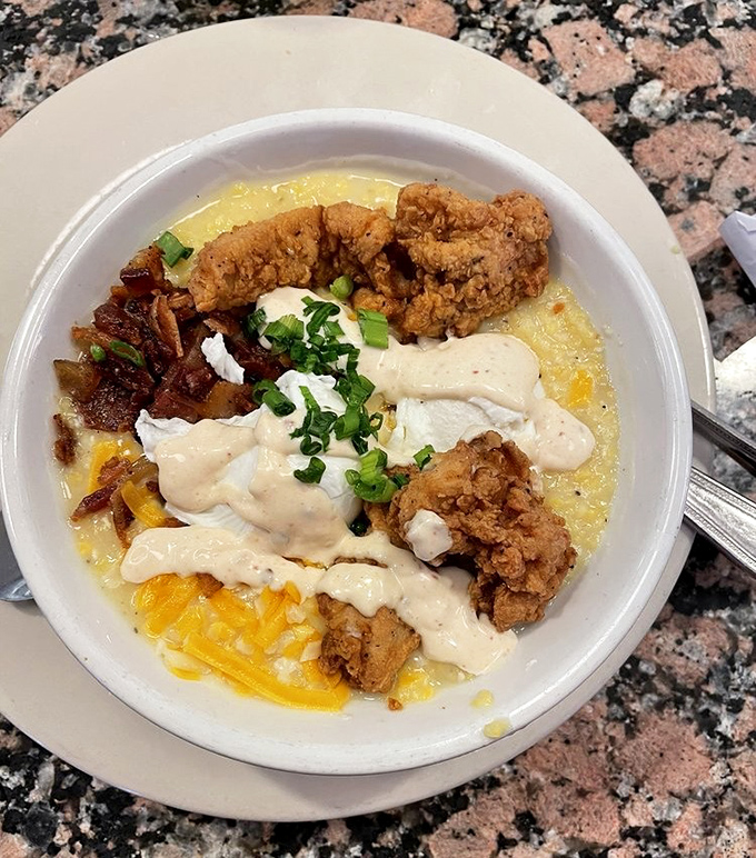 Southern comfort in a bowl. Crispy fried chicken nestles into creamy grits topped with gravy&mdash;proof that some traditions deserve to be preserved and savored slowly.