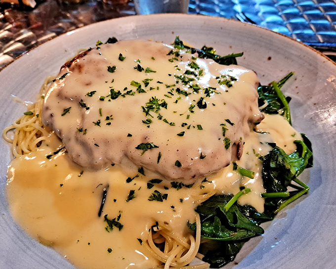 Pasta swimming in creamy sauce with perfectly seared scallops&mdash;proof that heaven exists and it's served on earthenware in Stuart, Florida.
