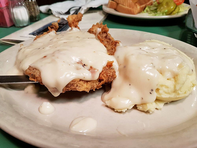 Chicken fried steak smothered in gravy that could make a vegetarian question their life choices. That mashed potato island is where I want to retire.