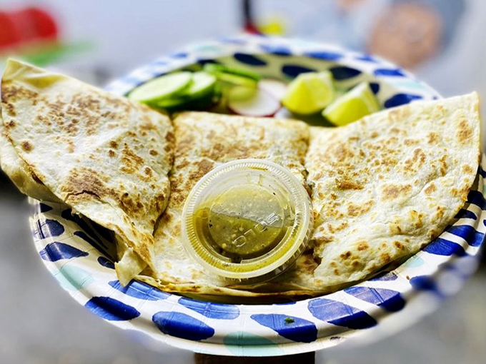 The quesadilla glistens with promise, its golden-brown exterior hiding a molten core of cheese that stretches with theatrical drama.