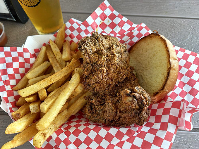 The fried chicken sandwich arrives like a crispy golden promise, surrounded by fries that clearly graduated from potato finishing school with honors.