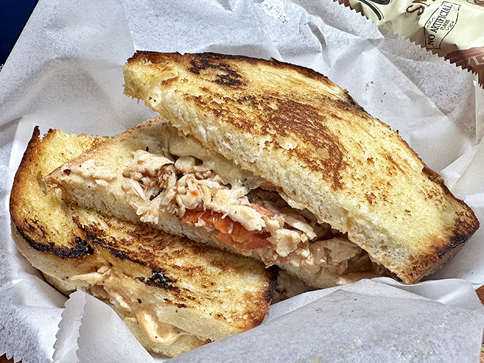 Behold the sandwich that launched a thousand return visits, nestled in paper like the culinary treasure it truly is.