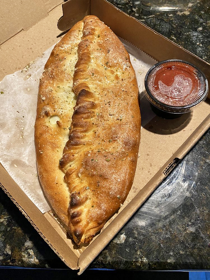 The stromboli&mdash;a magnificent dough canoe filled with treasure&mdash;sits ready for dipping in that little cup of marinara magic.