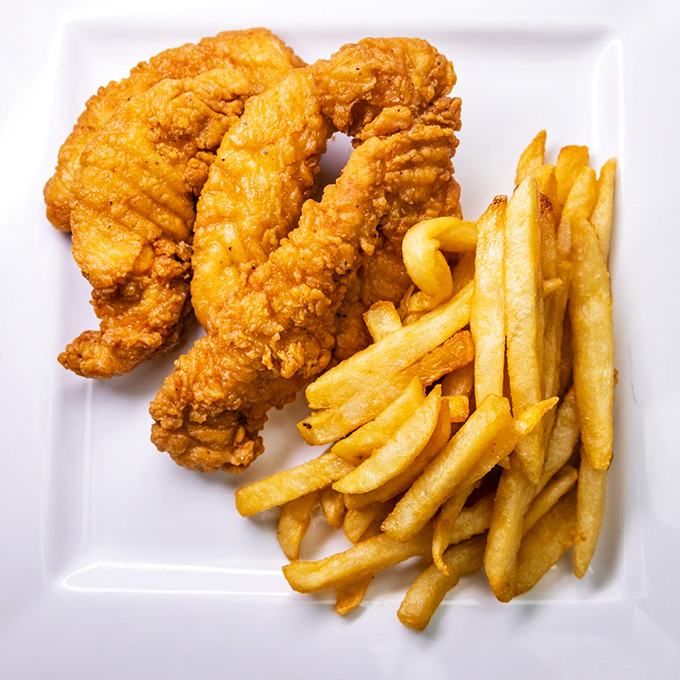 Golden-fried chicken tenders that crunch louder than your diet plan breaking, paired with fries that deserve their own fan club.