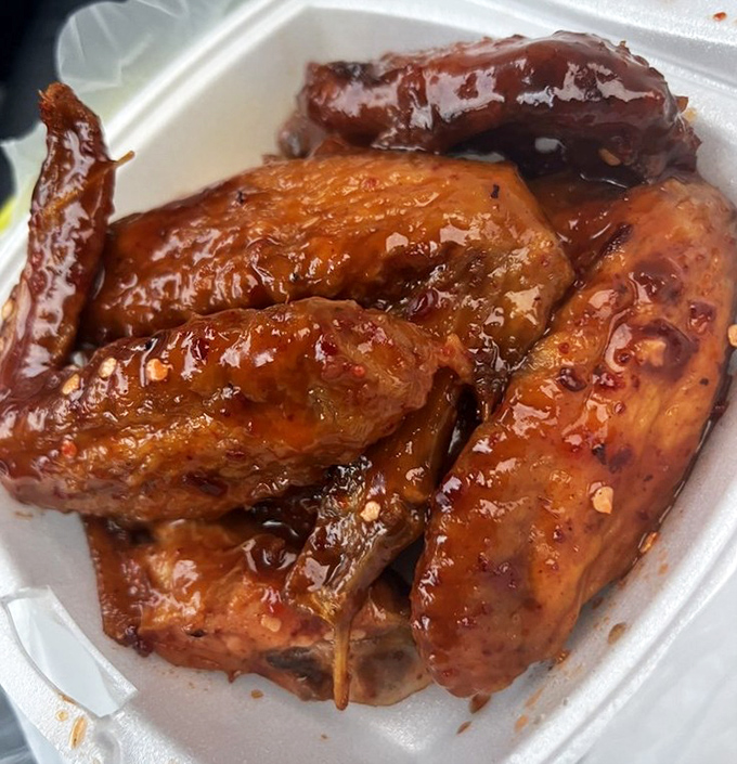 These aren't just wings; they're glistening ambassadors of joy. The sauce&mdash;sweet, spicy, and clinging to every morsel&mdash;might require a moment of silence.
