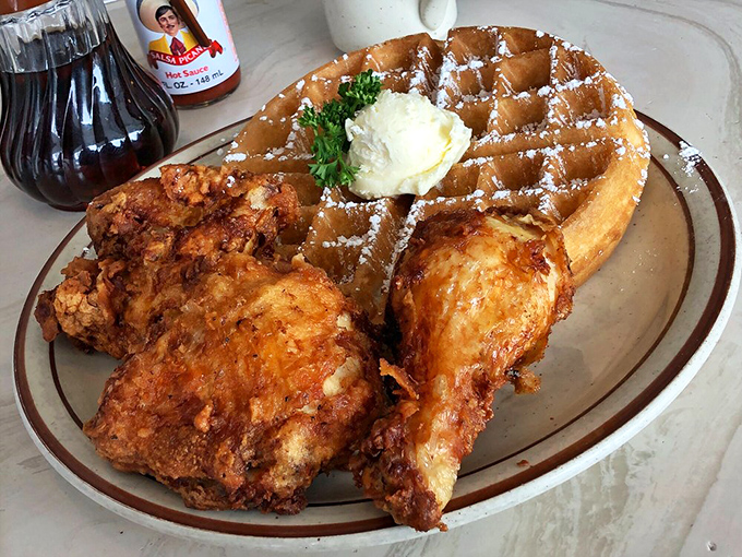 The ultimate sweet-savory romance: crispy fried chicken courting a golden waffle topped with butter and powdered sugar. It's the culinary equivalent of "When Harry Met Sally"—perfection.