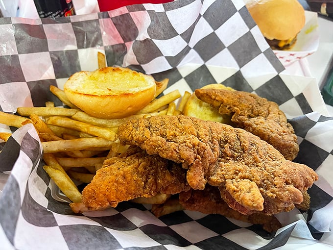 Golden-brown chicken tenders that crunch louder than your dad's favorite recliner, nestled beside fries that deserve their own fan club.