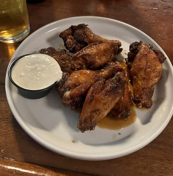 Wings so perfectly caramelized they make you wonder if they hired a chicken whisperer. That dipping sauce isn't optional &ndash; it's mandatory deliciousness.