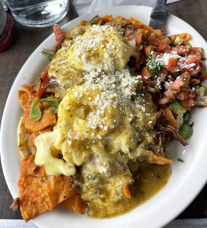 Chilaquiles that don't mess around—crispy tortillas swimming in sauce, crowned with eggs and a confetti of fresh pico de gallo.