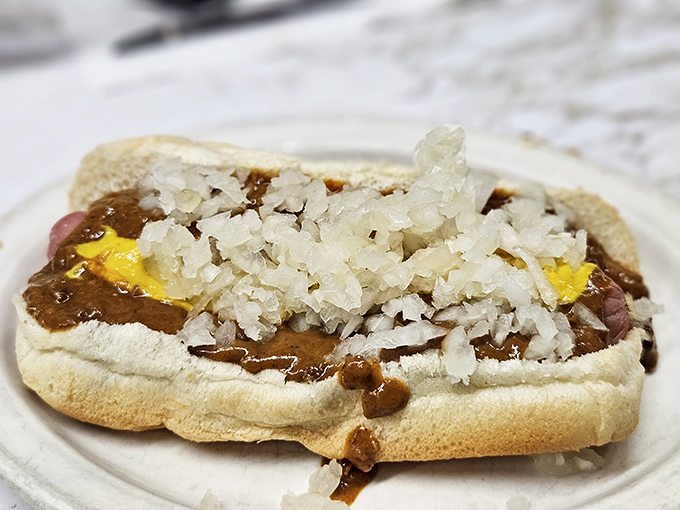 The proper Detroit coney experience includes diced onions that add both crunch and bite. This isn't food photography&mdash;it's edible history.
