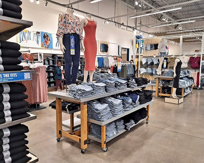 Denim democracy in action—where stacks of jeans await shoppers of all shapes and budgets. The American dream, folded neatly on wooden shelves.