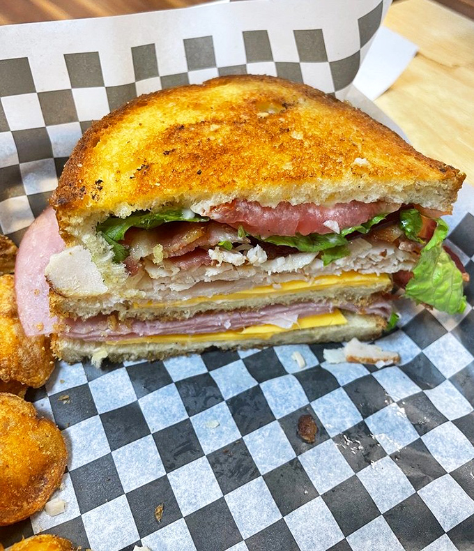 This club sandwich isn't messing around. Three layers of bread creating the perfect architecture for a skyscraper of meat, cheese, and veggies. Sandwich engineering at its finest.