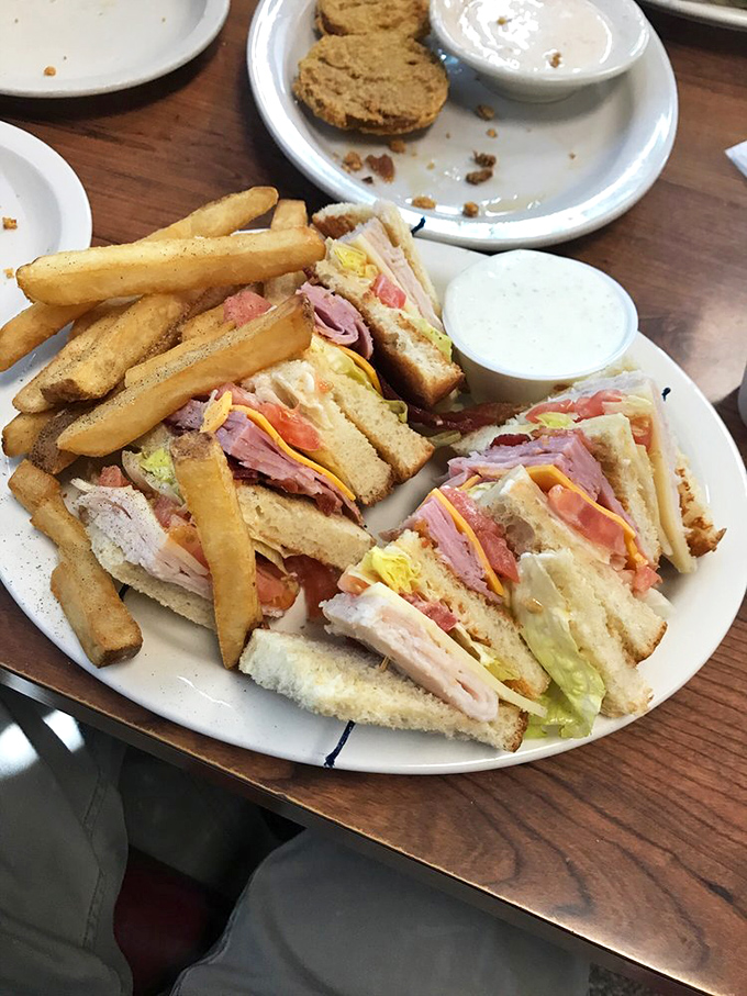 The club sandwich: architectural marvel of the Midwest. Stacked higher than a corn silo with layers that tell a delicious story of American abundance.