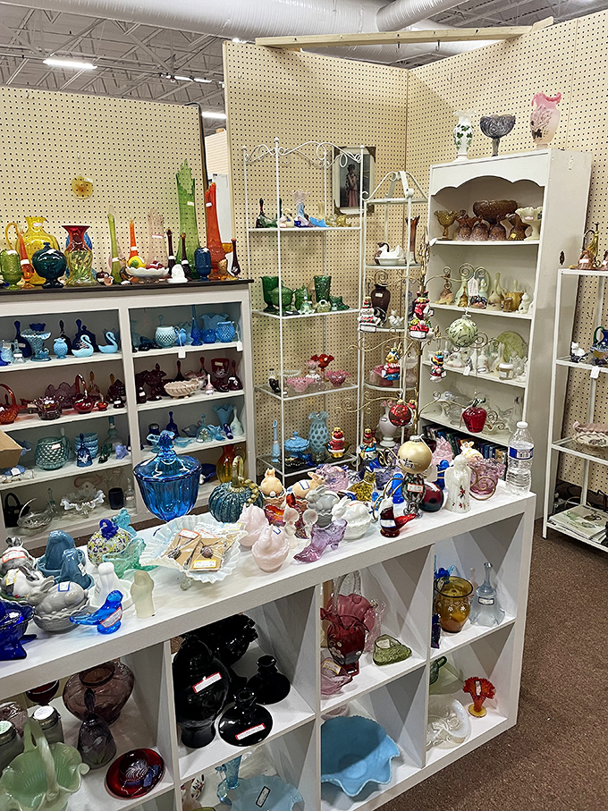 A rainbow of vintage glassware catches the light like jewels. Depression glass, Fenton pieces, and carnival glass create a kaleidoscope of color.