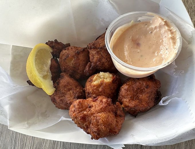 These conch fritters aren't just appetizers; they're little spheres of happiness with a side of tangy dipping sauce.