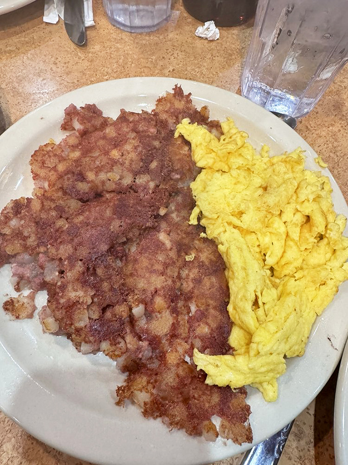 Crispy corned beef hash alongside fluffy scrambled eggs—a breakfast duet that performs in perfect harmony on your taste buds.
