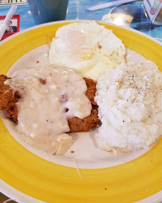 Country fried steak smothered in gravy that's thicker than the plot of a soap opera, with eggs and mashed potatoes standing by for support.