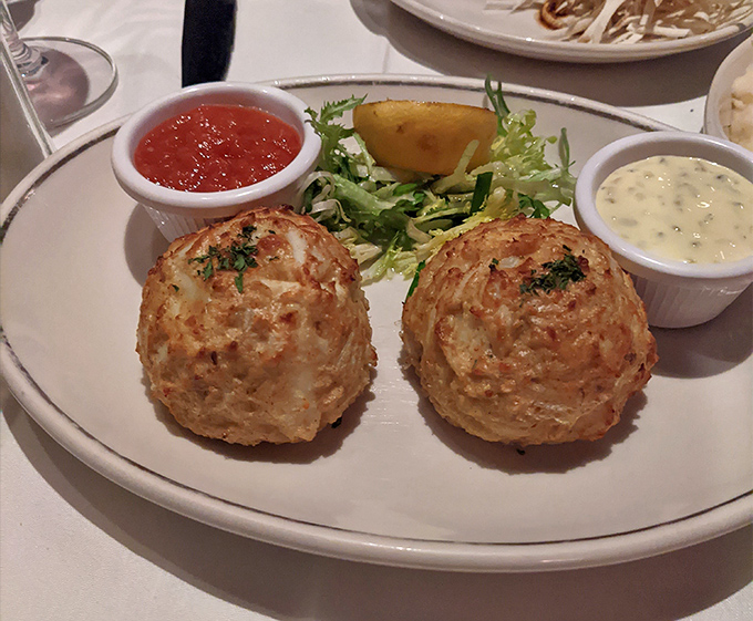 Maryland's famous crab cakes, golden-brown and barely bound. These delicate spheres of jumbo lump crabmeat contain so little filler they seem to defy the laws of physics.