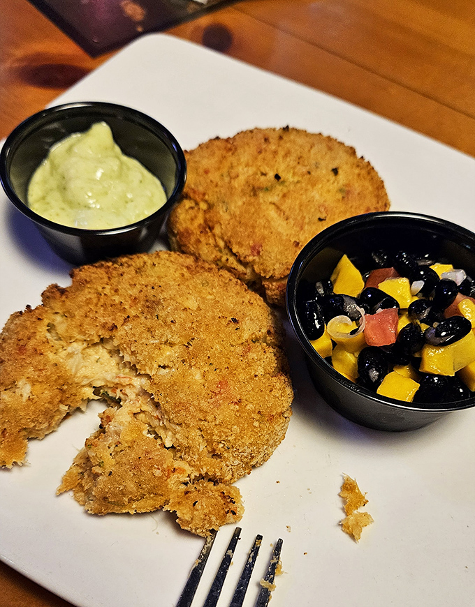 Golden-crusted crab cakes with a vibrant mango-black bean salsa&mdash;proof that sometimes the best seafood doesn't swim to your plate, it struts.