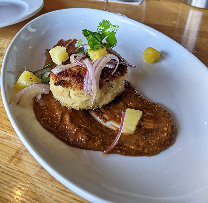 This isn't just any crab cake&mdash;it's a golden-crusted island of crab perfection, surrounded by a sea of sauce that demands to be savored.