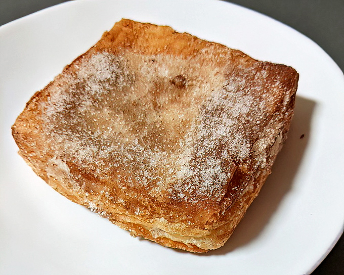 The humble beignet-style square, dusted with powdered sugar like the first snow of winter. Simple perfection that transports you to New Orleans without the airfare.