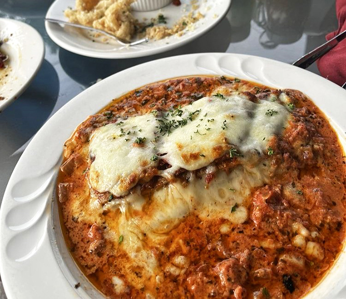The Eggplant Lasagna arrives like a bubbling cauldron of comfort, layers of flavor that would make any Italian grandmother weep with joy.
