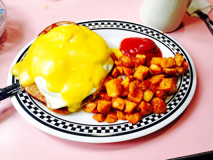 Hollandaise sauce cascading over an English muffin like a golden waterfall, with home fries that could make a potato farmer weep with joy.