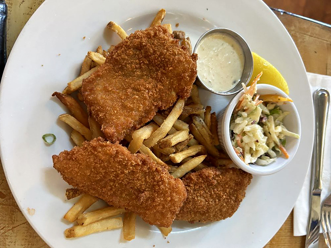 Crispy on the outside, flaky within &ndash; this fish and chips platter isn't just food, it's edible sunshine accompanied by creamy coleslaw and tangy tartar sauce.