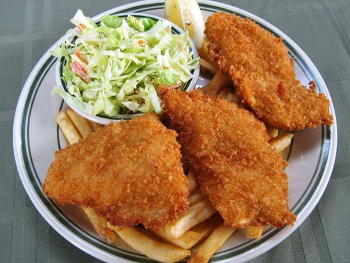 Golden-battered fish that crunches like autumn leaves, served with fries that somehow maintain their dignity even under the weight of expectation.