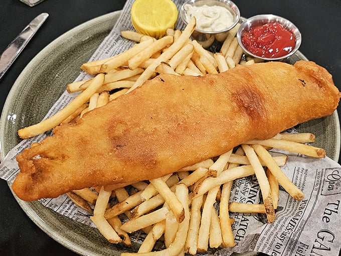 Fish and chips that would make a British pub-goer weep with joy, served on newspaper because some traditions are worth keeping. 