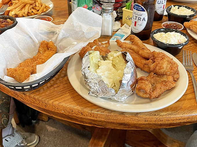 The fish dinner comes with a baked potato wrapped in foil like a tiny silver astronaut, ready to blast off to flavor town.