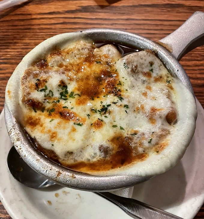 French onion soup so perfectly browned and bubbling, it's like watching a cheese volcano erupt in slow motion. Spoons ready for rescue operations!