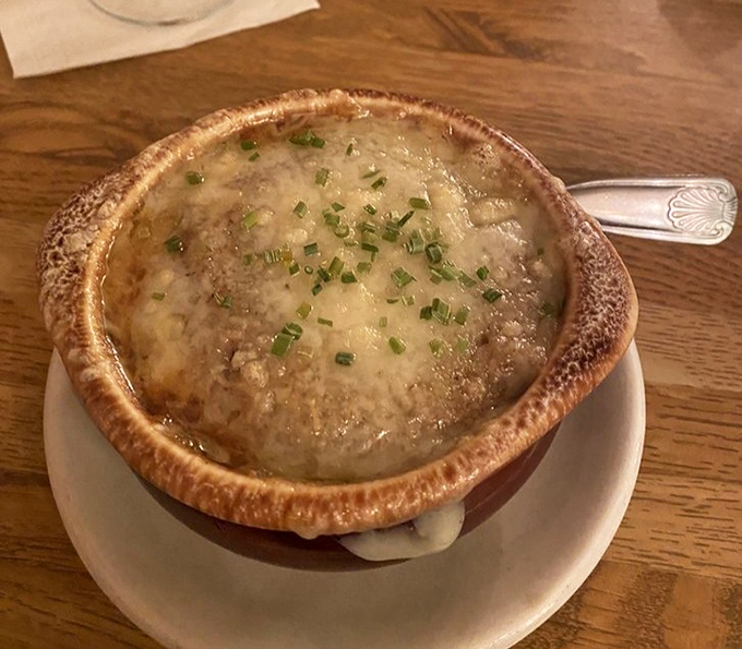 This isn't just soup—it's a bubbling cauldron of French onion goodness, where cheese stretches dramatically with every spoonful.