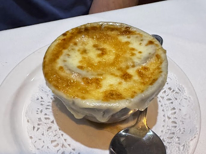 French onion soup so good it should have its own passport. That golden, bubbling cheese top is basically a security system protecting the treasures below.