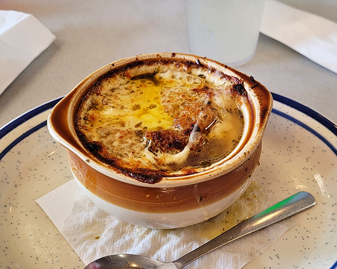 French onion soup so good it could broker peace between actual French and onion skeptics, crowned with a cheese cap that deserves its own monument.