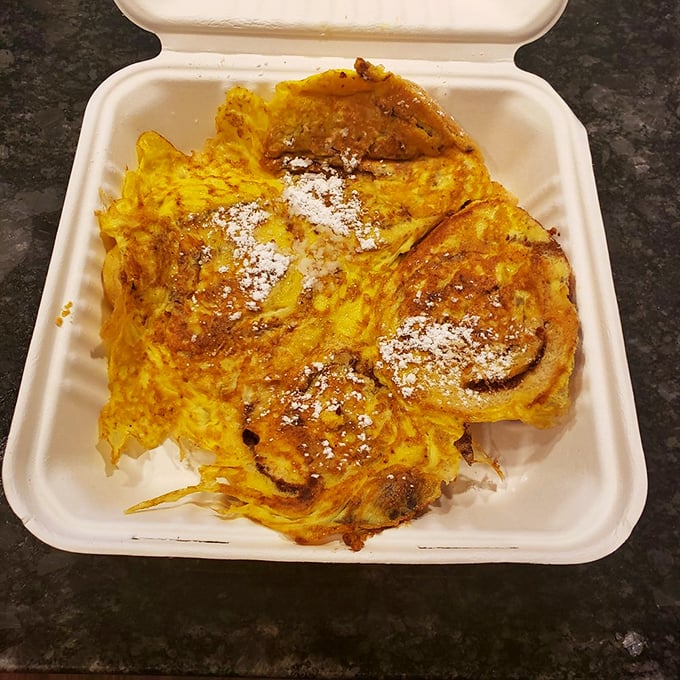 French toast that could make a Parisian weep, dusted with powdered sugar and topped with a butter pat melting like a summer sunset.