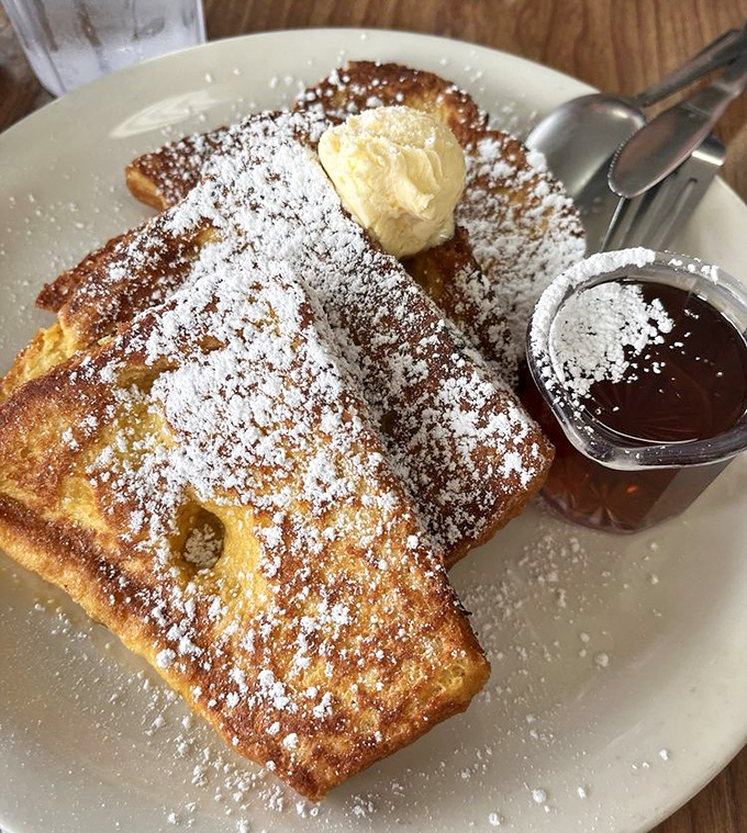 French toast that doesn't need a passport to impress. That dusting of powdered sugar and melting butter creates a breakfast that's both simple and sublime.