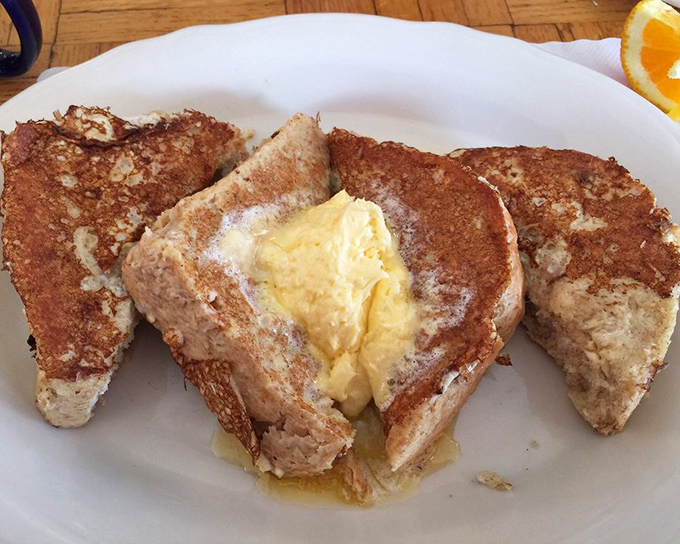 French toast so fluffy it practically floats off the plate, dusted with powdered sugar perfection.