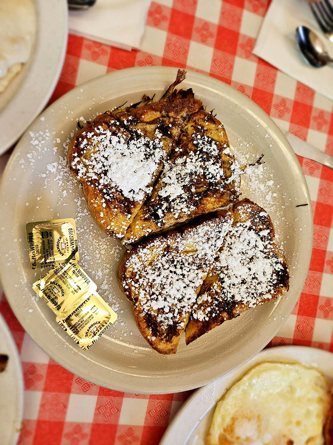 French toast perfection arrives dusted with powdered sugar, transforming ordinary mornings into memorable celebrations.
