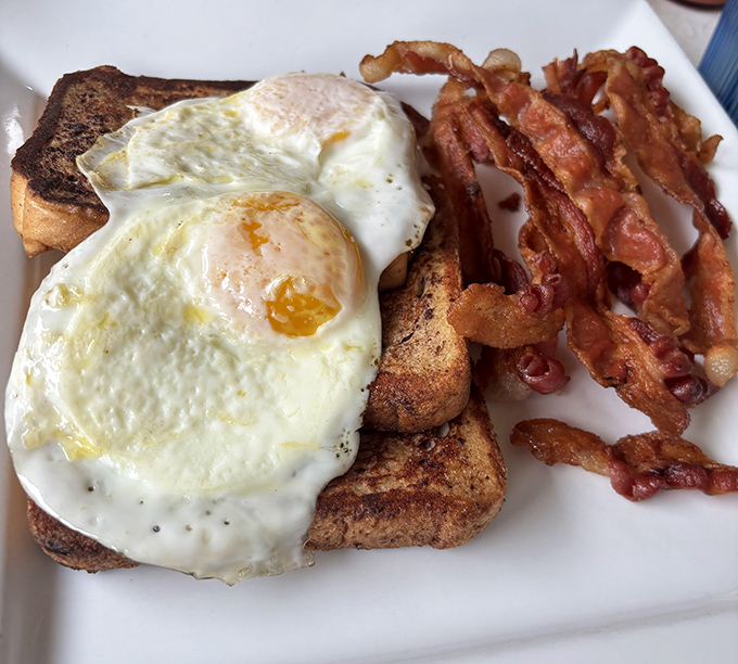 Sunny-side up eggs with perfectly crisped bacon—the breakfast equivalent of hitting all green lights on your morning commute. Simple perfection on a plate.