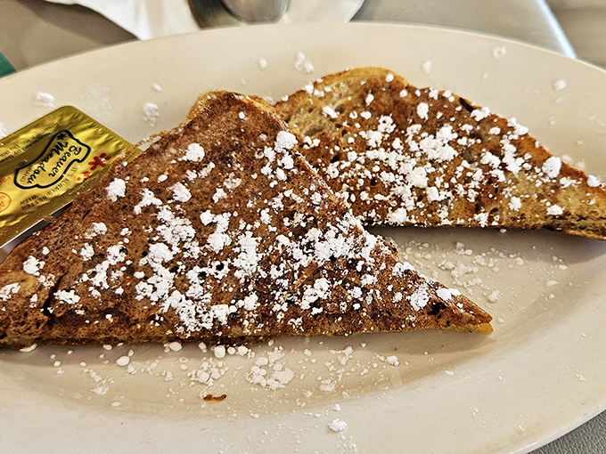 French toast so perfectly dusted with powdered sugar, it looks like breakfast snow fell from culinary heaven.
