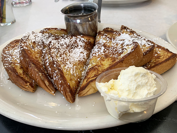 French toast that deserves its own fan club. Perfectly caramelized exterior, custardy interior, and enough powdered sugar to make your dentist wince. Worth every calorie!