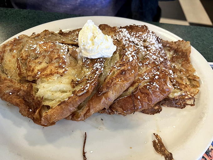 This isn't just French toast &ndash; it's croissant French toast that's living its best life with a dollop of whipped cream and powdered sugar confetti.