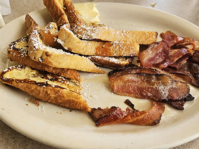 French toast that's achieved the impossible trifecta: crispy edges, custardy centers, and enough powdered sugar to make your childhood self high-five your adult self.
