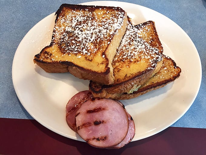 French toast that's dressed better than most people on Sunday morning&mdash;powdered sugar dusting and a side of ham that means business.